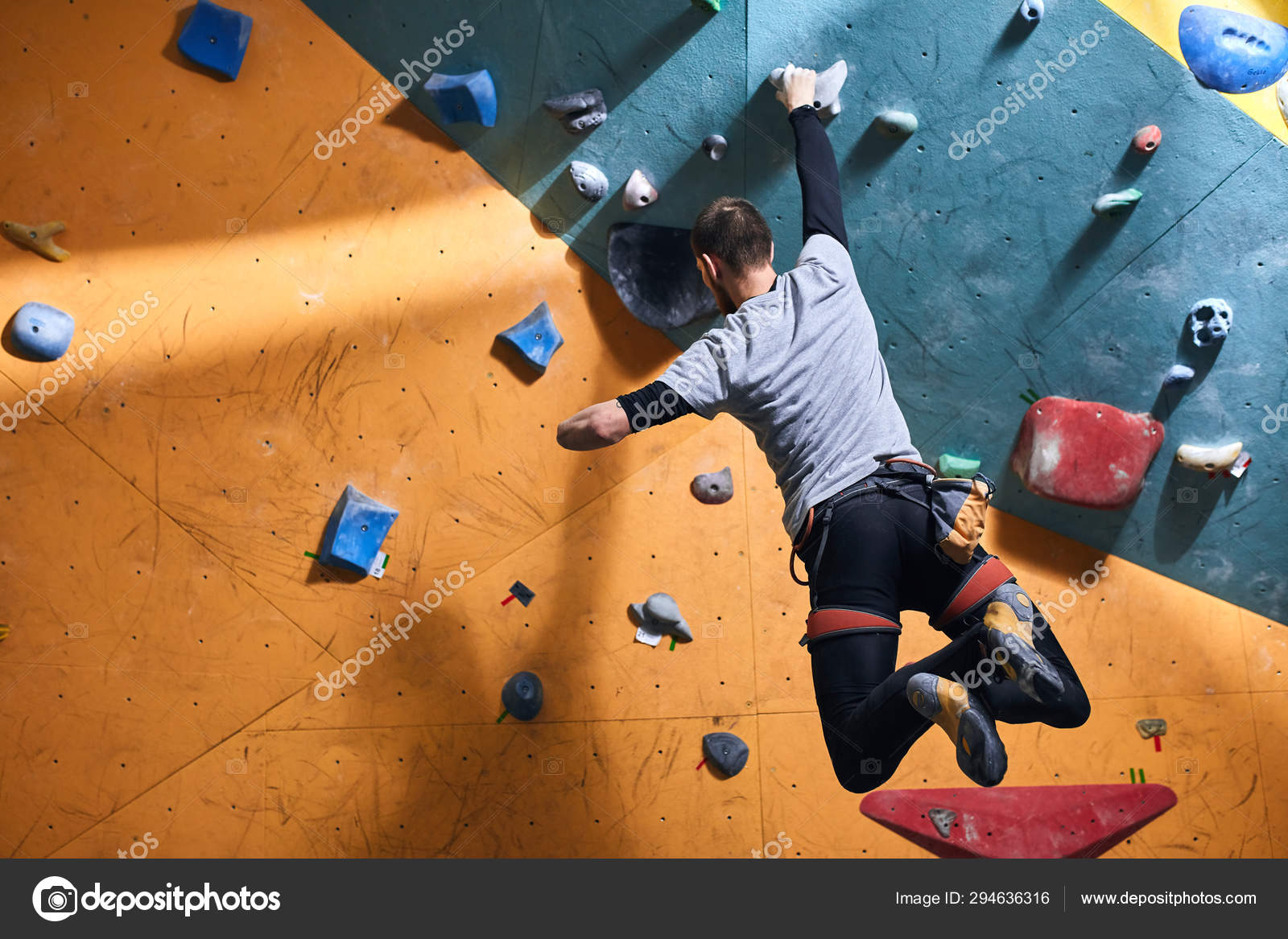 Boulderer with physical disability hanging at rock wall, balancing on ...