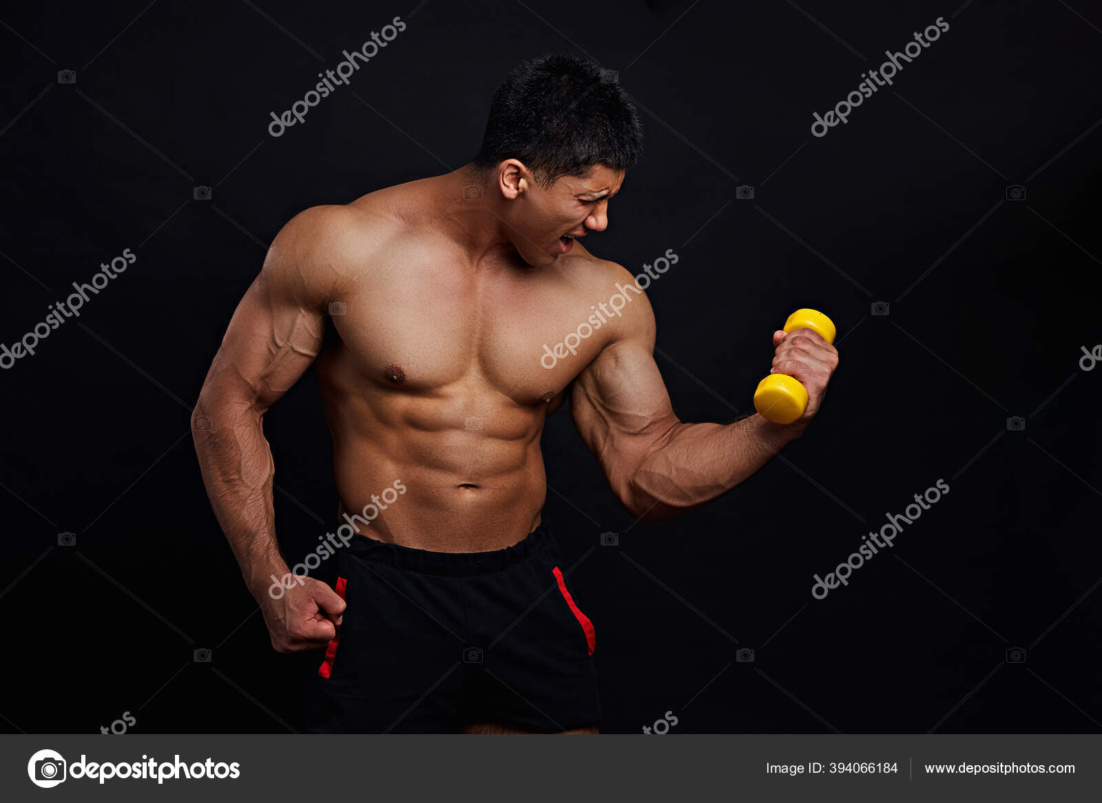 Frustrated angry guy doing exercises with dumbbell over black ...