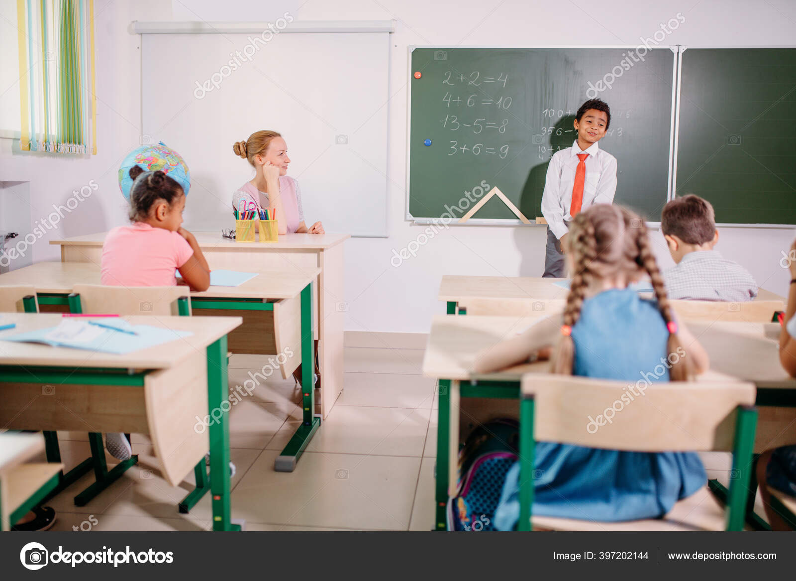 Boy solving addition and subtraction on board. schoolboy writing ...
