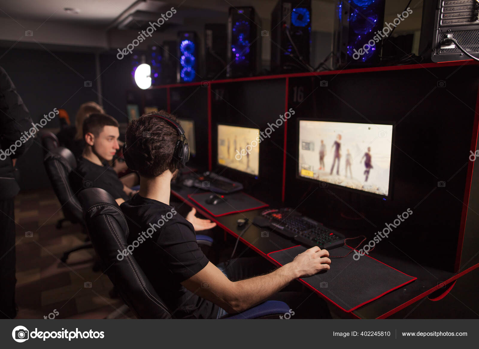 Backside of gamers participating in online cyber tournament, at pc ...