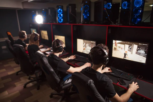 Backside of gamers participating in online cyber tournament, at pc ...