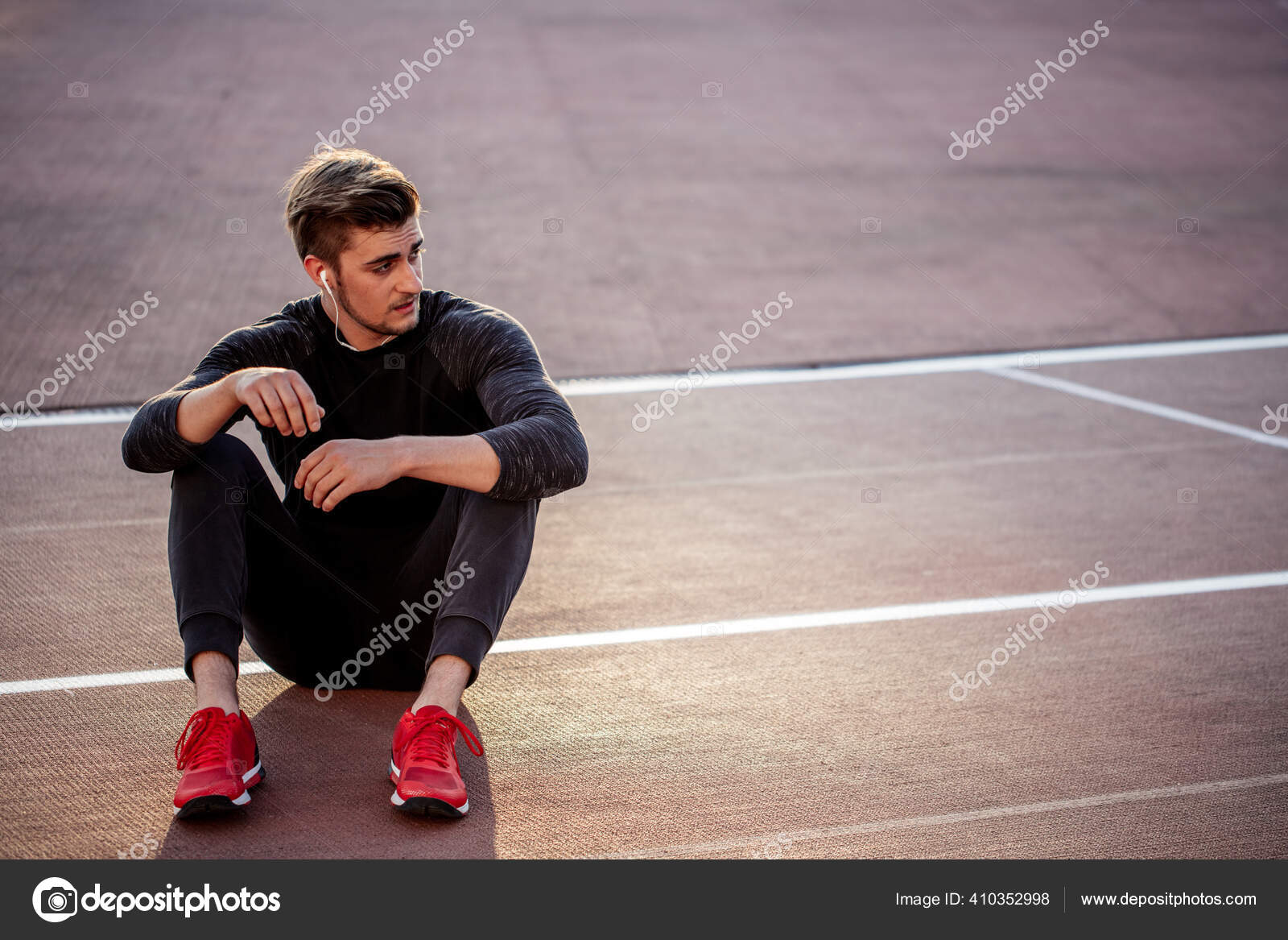 Time to rest. man resting after running on track in stadium — Stock ...
