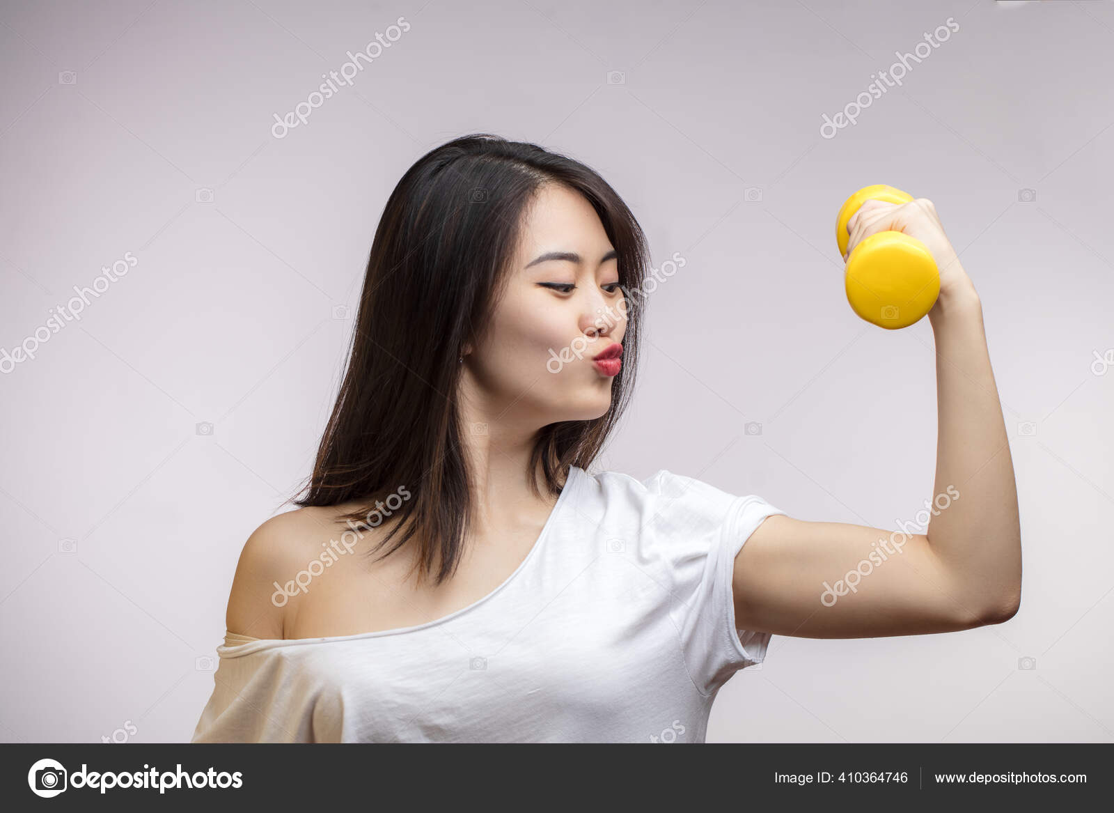 Asian woman with dumbbells, shows her strength, training biceps ...