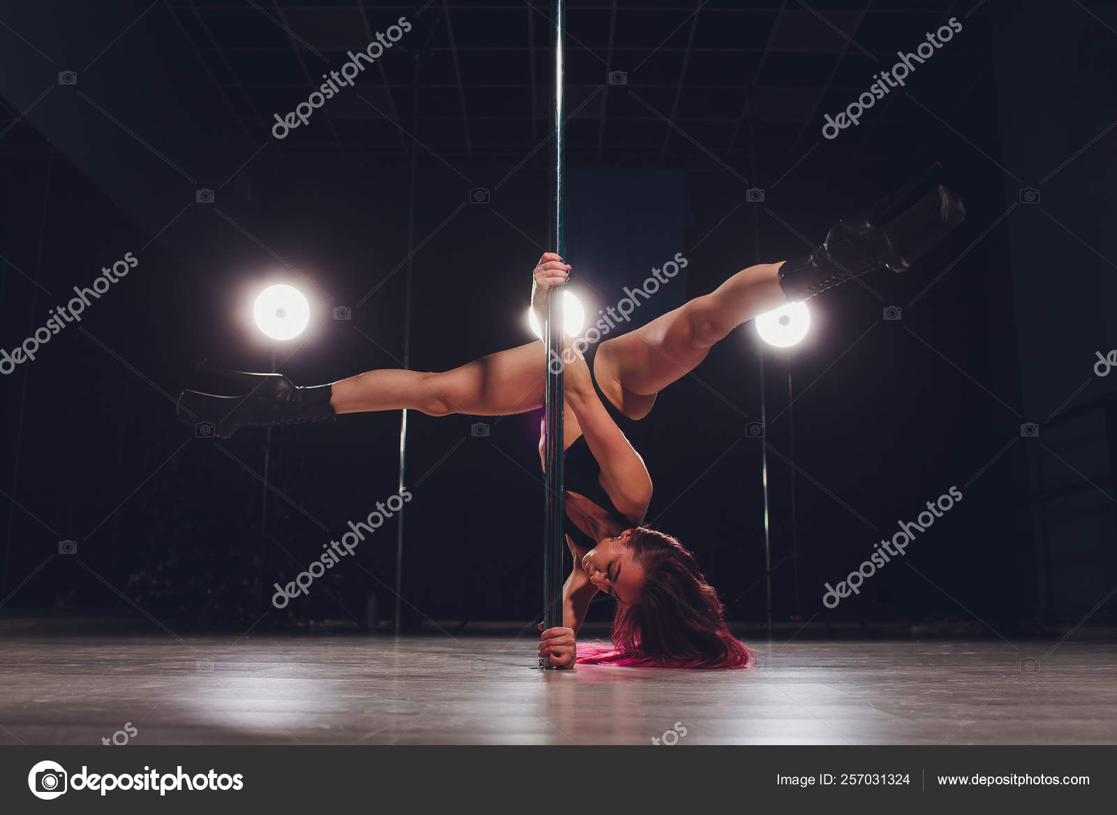 Joven mujer de baile polo sobre fondo de pared negro con efecto de bengala. Cuerpo deportivo en ...