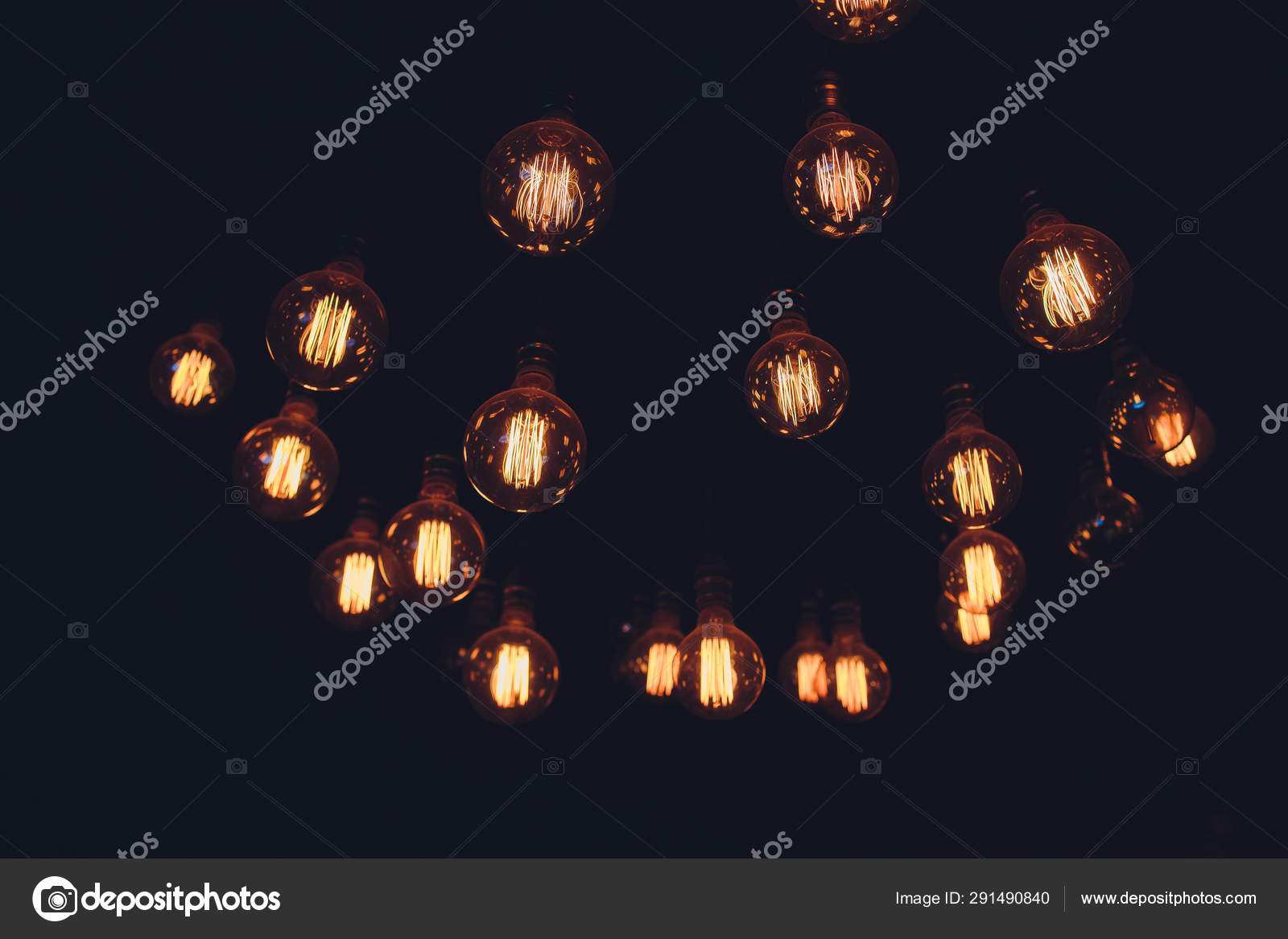 Close-up of a round huge light bulb glows in golden color against a ...