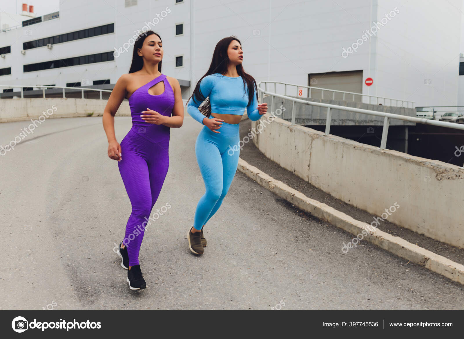 Two female athletes training racing running upstairs on city stairs in ...