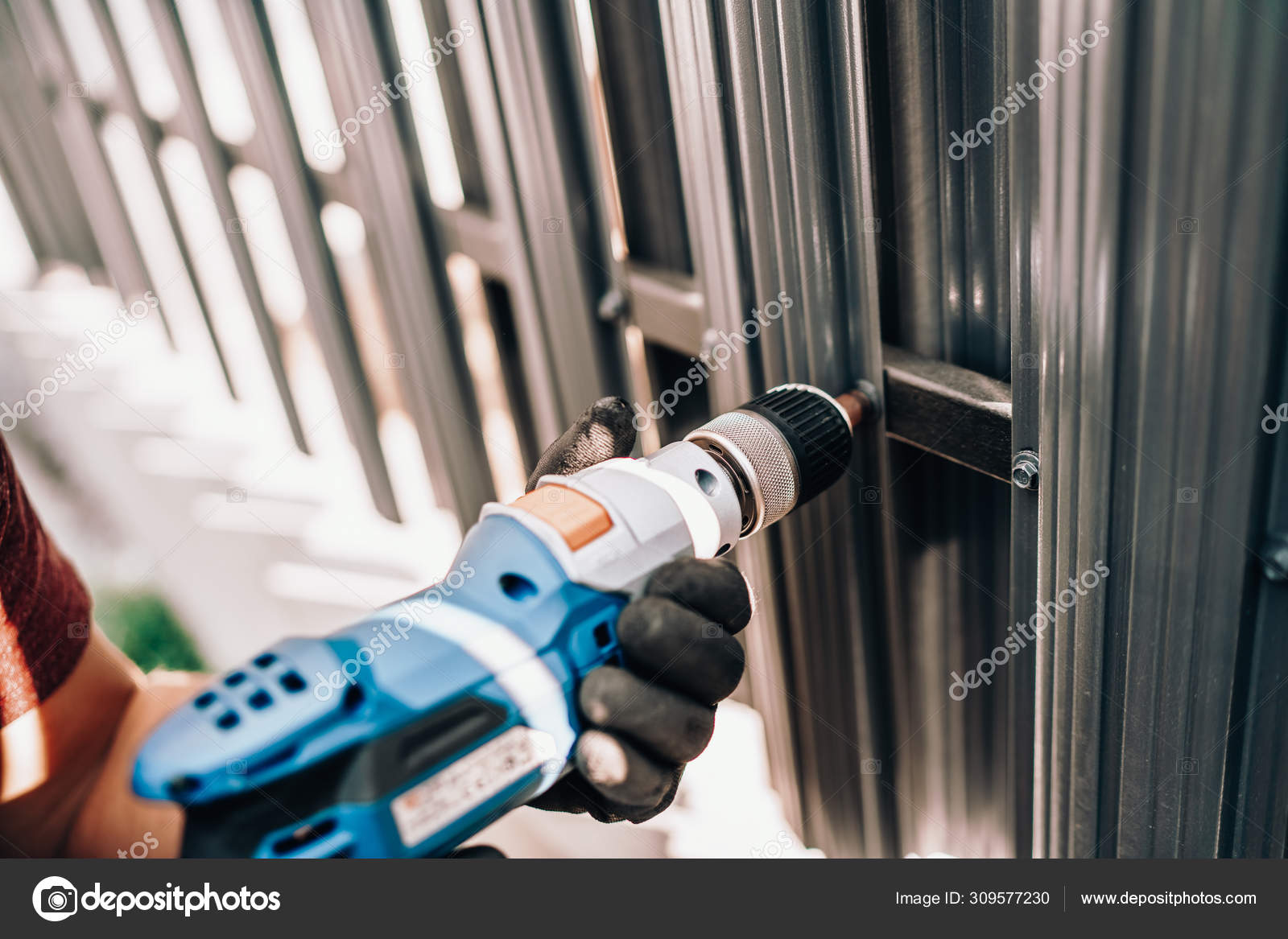 Handyman worker using electrical cord screwdriver for fastening screws ...
