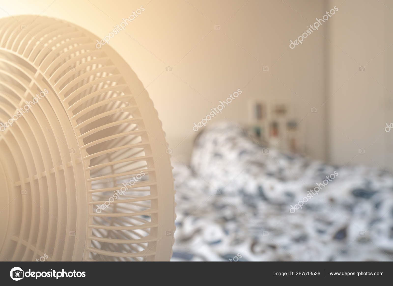 Person sleeping in bed with a fan blowing on hot summer day Stock Photo ...
