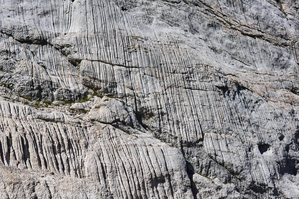 superficie gris de un acantilado escarpado, forrada de surcos ...