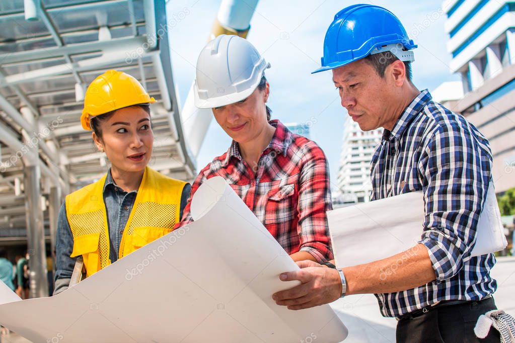 Tres ingenieros industriales usan ingenier a de casco de seguridad trabajando y hablando con la ...