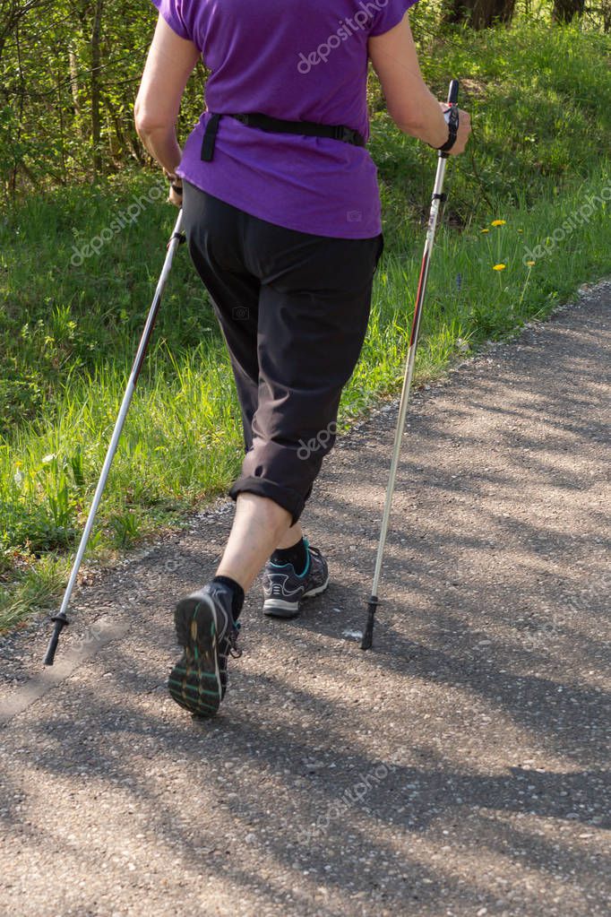 señora nórdica caminando en el parque de primavera con chaqueta negra ...