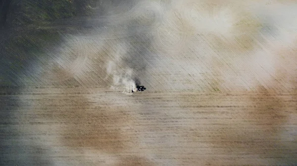 Aerial top down view of Tractor cultivating field at spring, aerial top ...