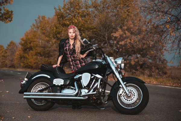 Beautiful biker woman posing with motorcycle on the road. - Stock Image ...