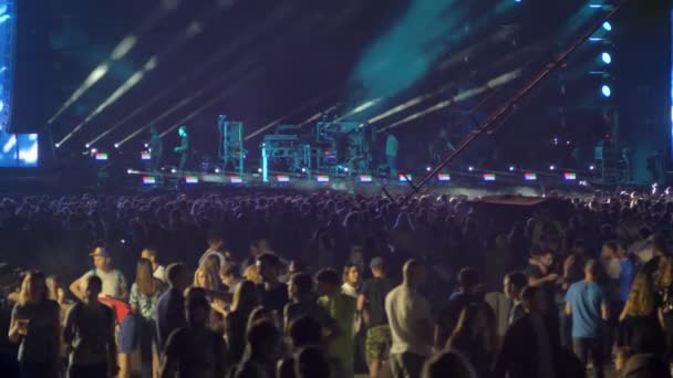 Footage of crowd gathering and waiting for beginning of rock concert ...