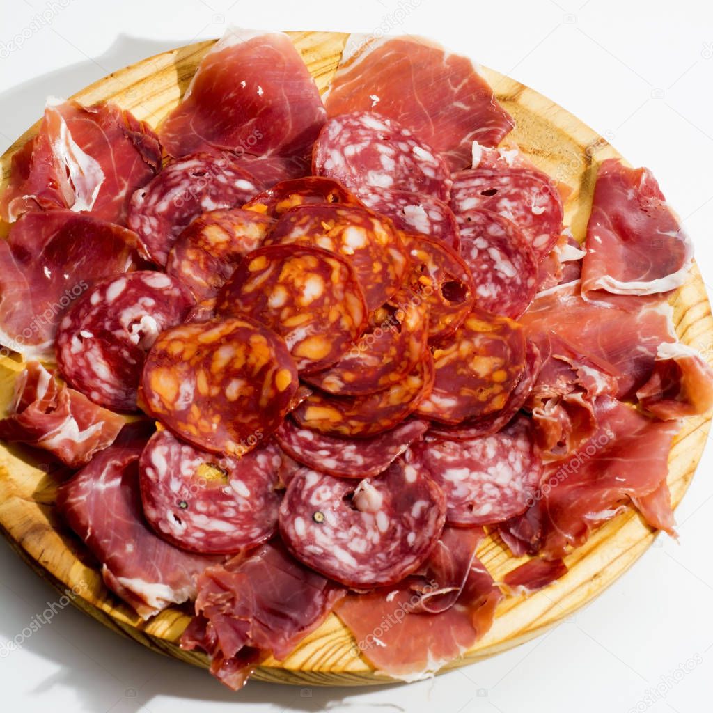 Comida típica española con jamón y salchicha en un plato de madera 2022
