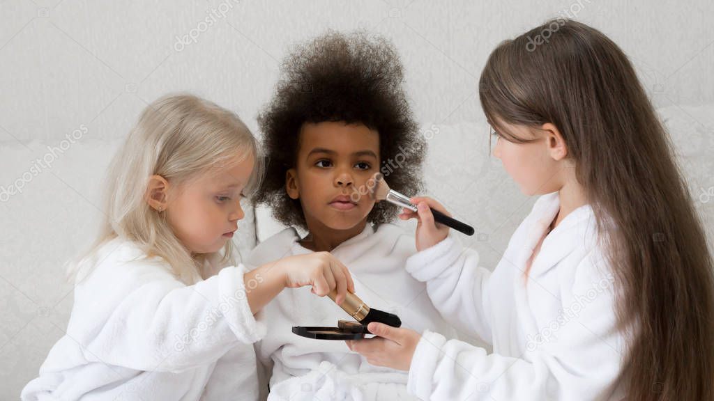 Las niñas juegan con maquillaje mientras están sentadas en el sofá ...