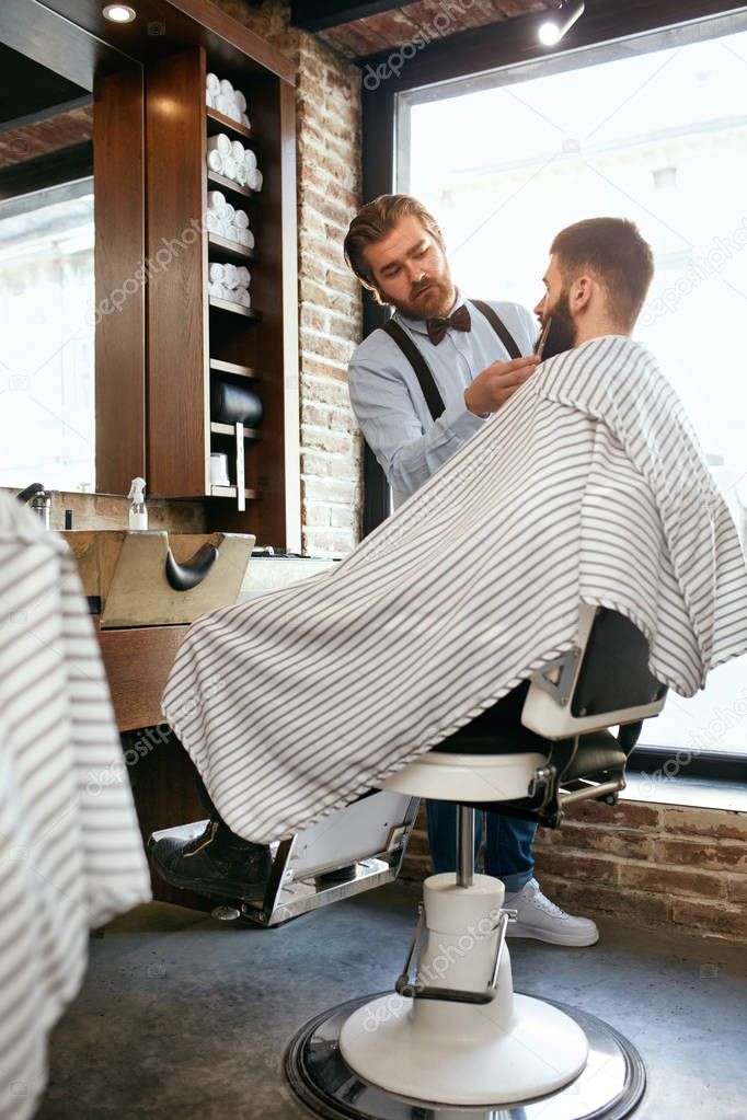 Barbero cortando la barba del hombre en la peluquería. Peluquería ...