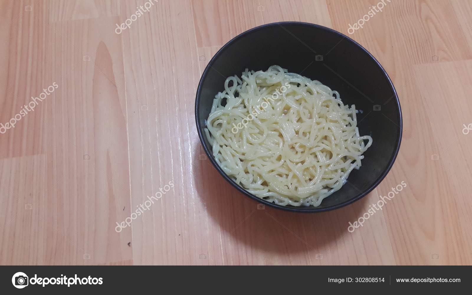 Close up view of swirling noodles or spaghetti pasta in a bowl over ...