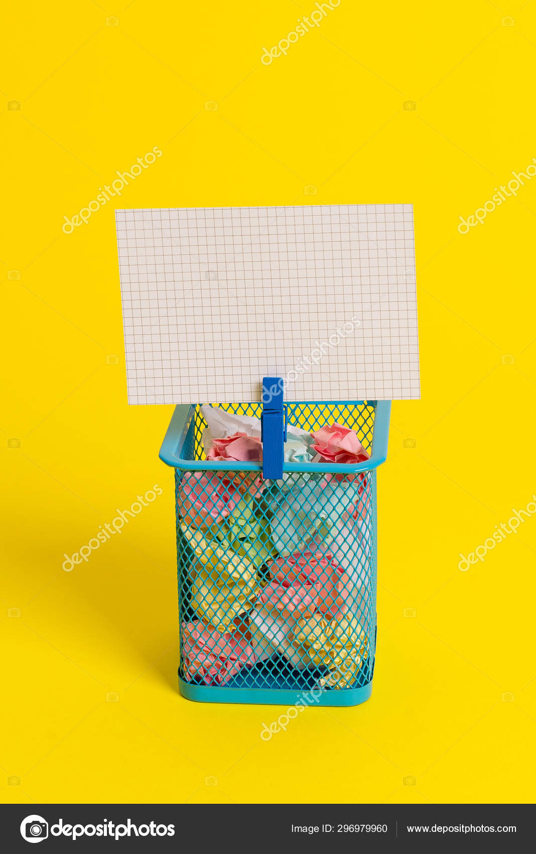 Little trash bin full of crumpled colored paper and a blue clothespin ...