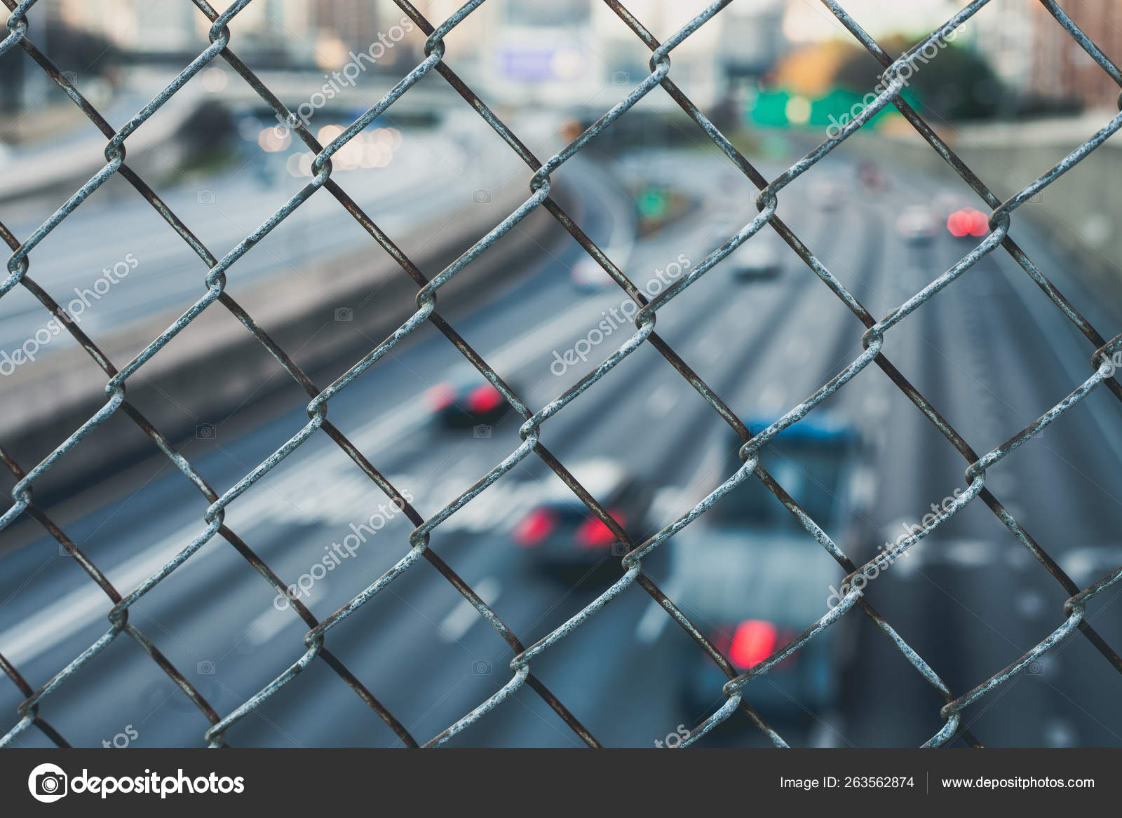 City skyline through the wire mesh fence. Abstract blurred cityscape ...