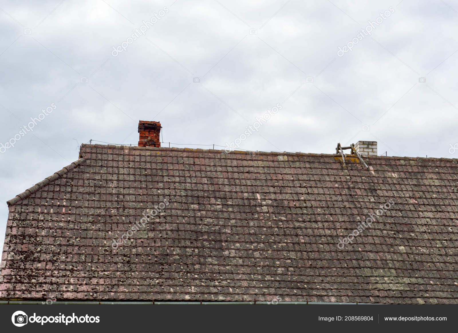The old ancient sloping triangular roof of the house, the cottage is ...