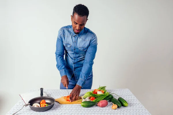 young black man cooking at home domestic kitchen and preparing a ...