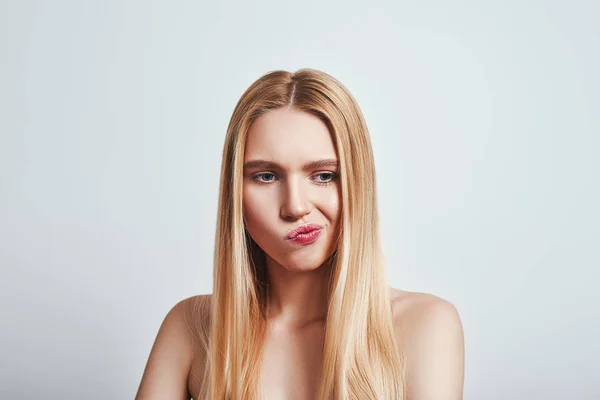 Hm...I do not know what to do. CLose-up portrait of young blonde woman ...