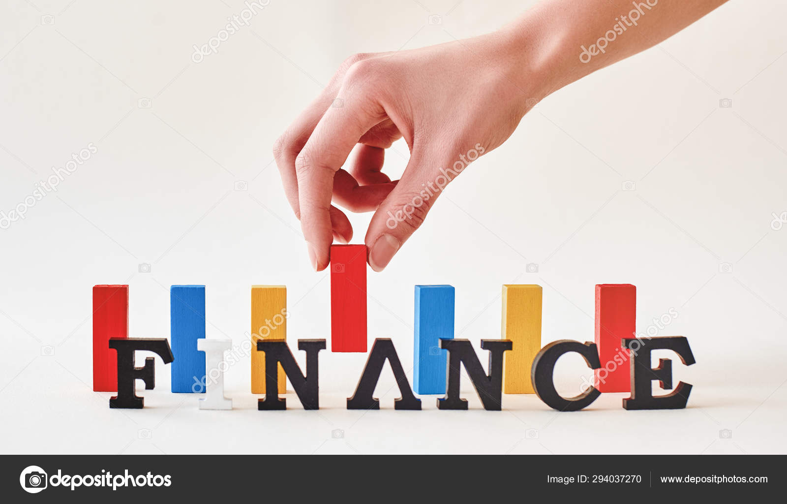 Finance word created with alphabet letters. Hand placing multi-colored ...