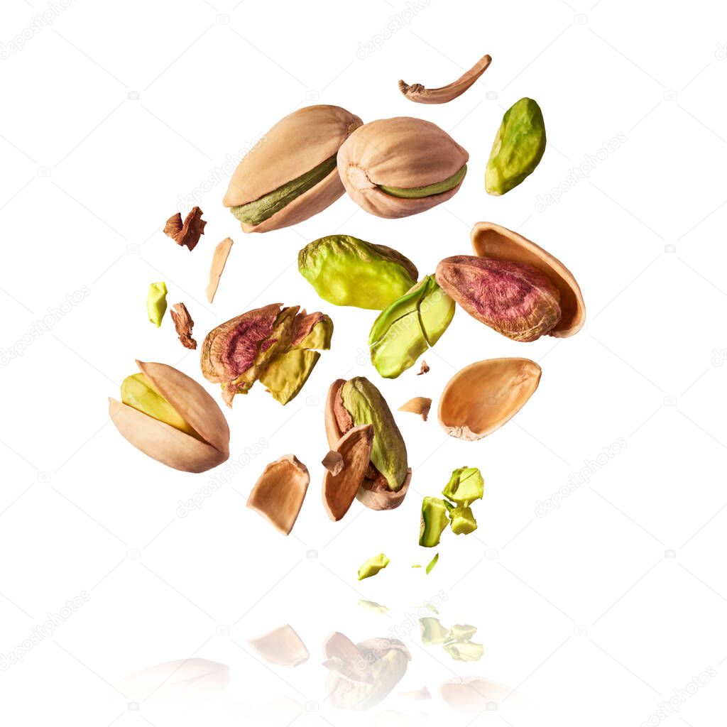 Volando en aire fresco crudo entero y pistachos agrietados aislados ...