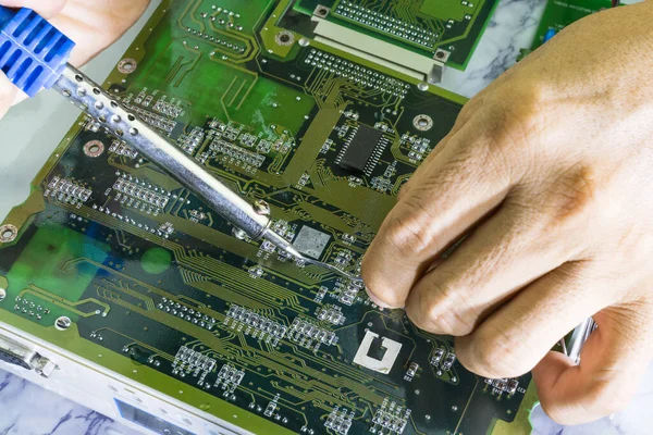 Technicians are using a soldering iron for repairing electronic of the ...