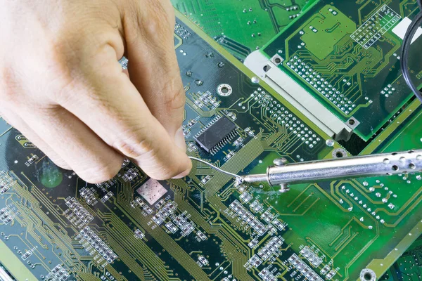 Technicians are using a soldering iron for repairing electronic of the ...