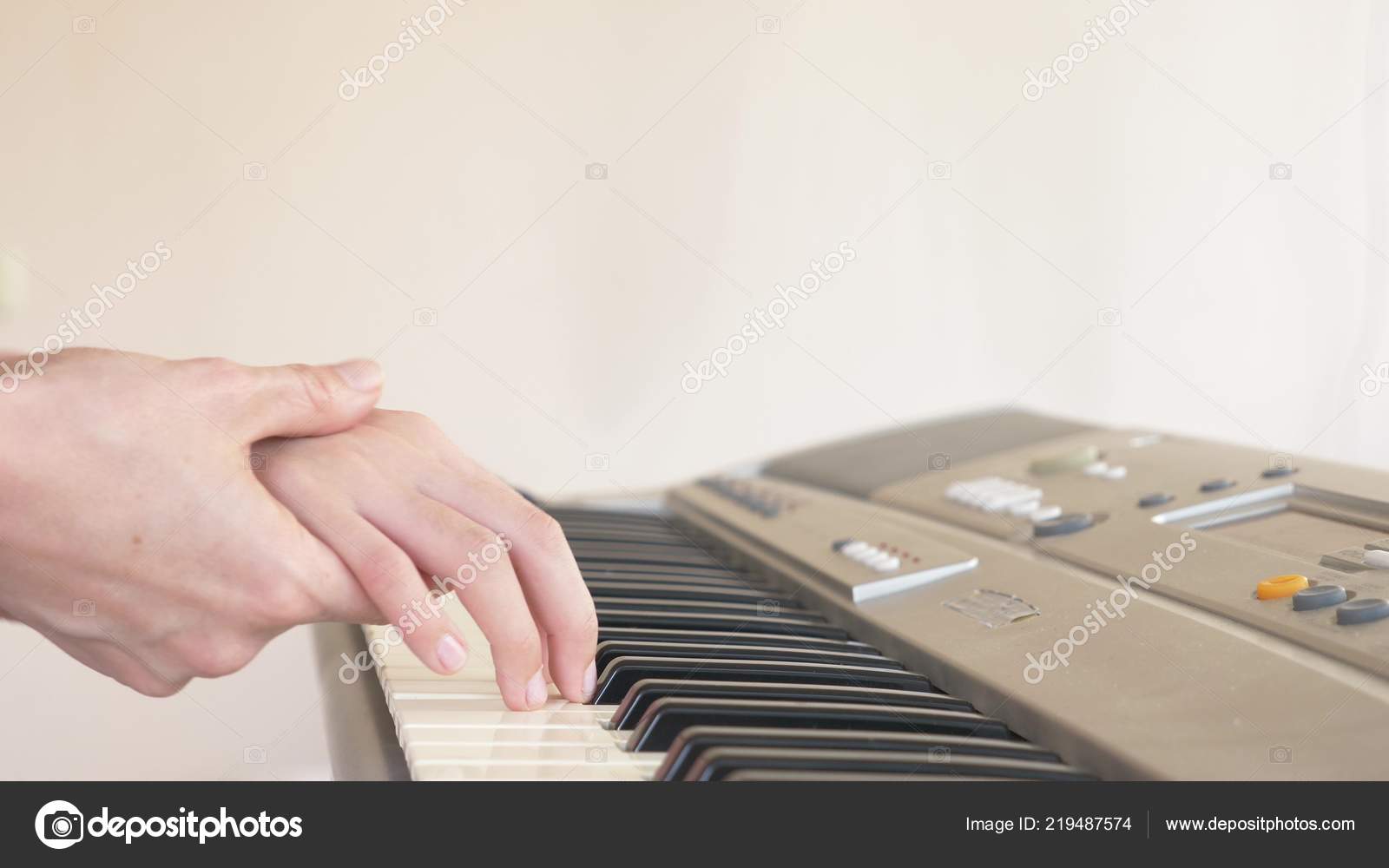 Close-up. a piano teacher teaches a child to play the piano, setting ...