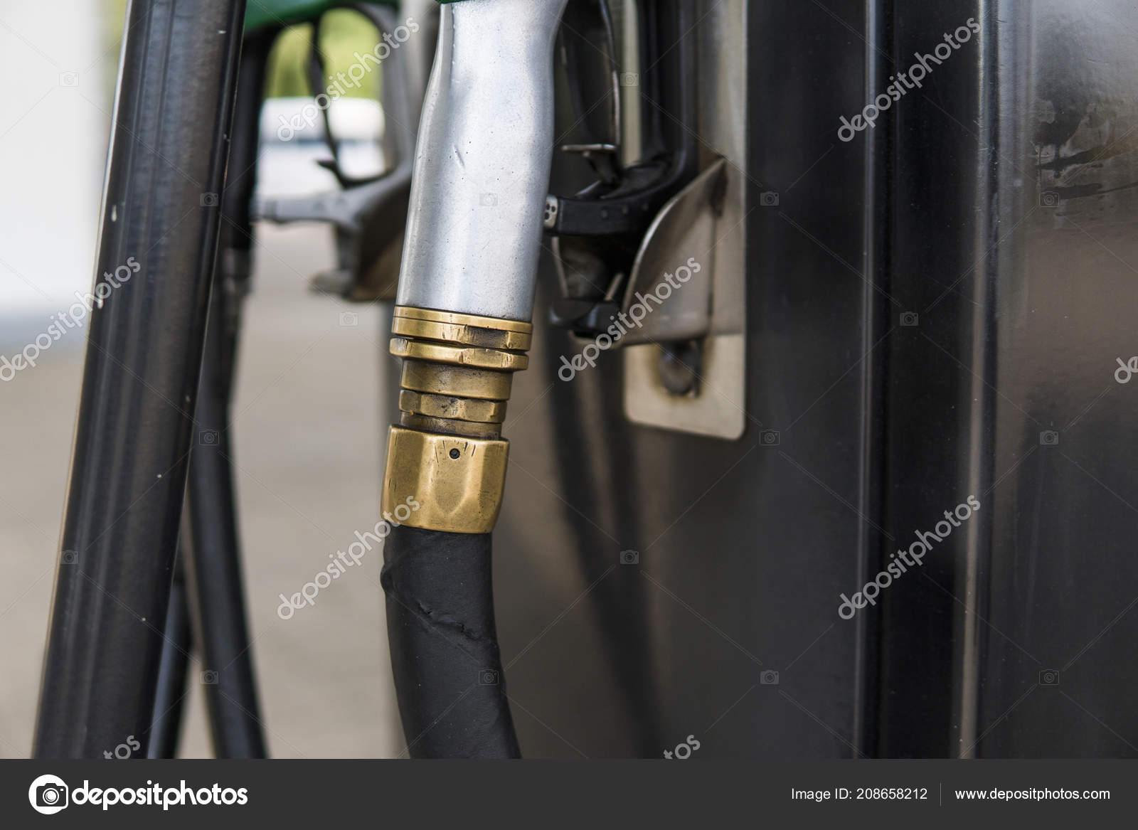 Close up on dirty fuel nozzle in oil dispenser with gasoline and diesel ...