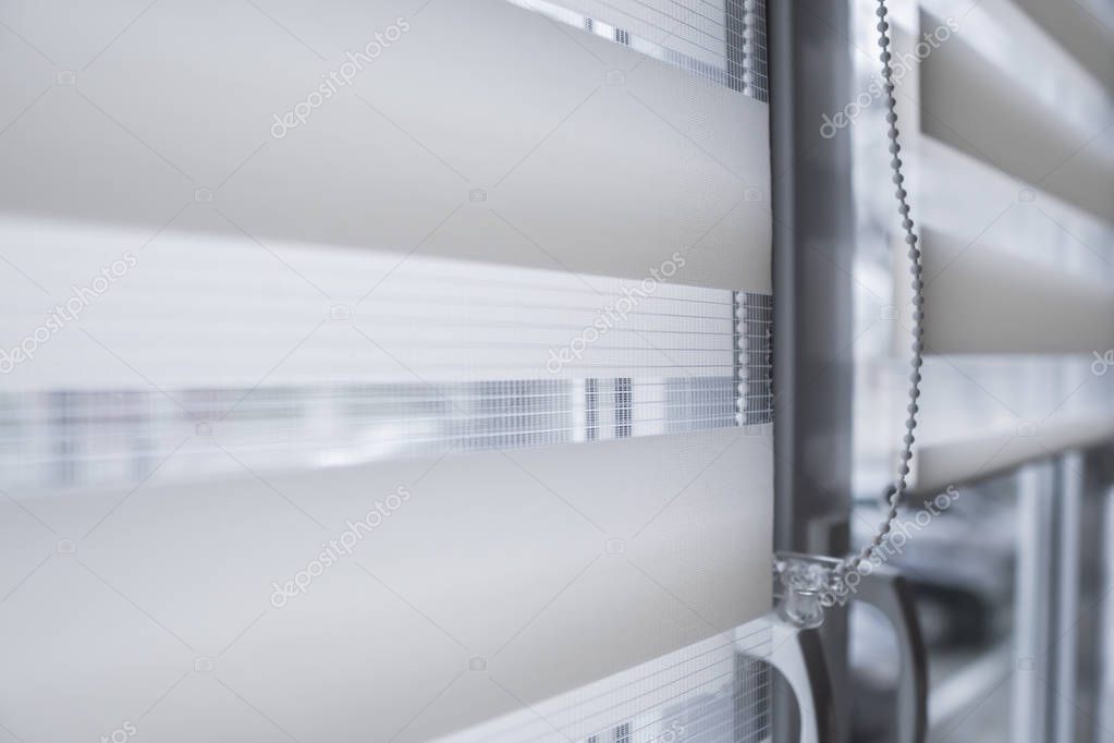 Detalles de persianas enrollables de tela blanca en la ventana de ...