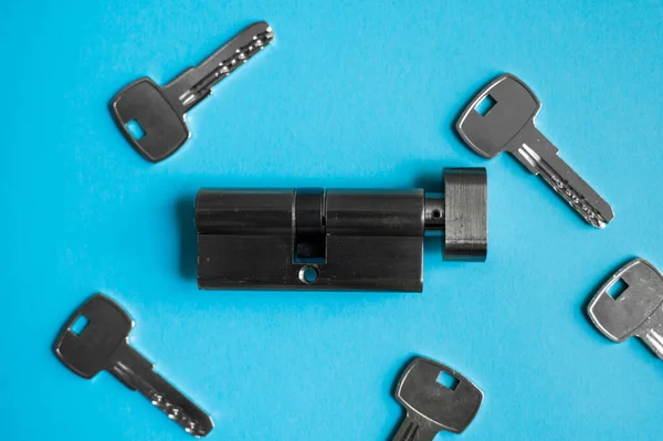 A door lock cylinder core with keys on the yellow background. The ...