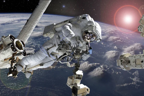 Astronaut flying in outer space near planet earth doing some work near ...