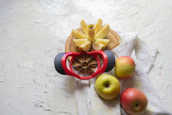 Round apple slicer on a board, making eight segments for breakfasts ...