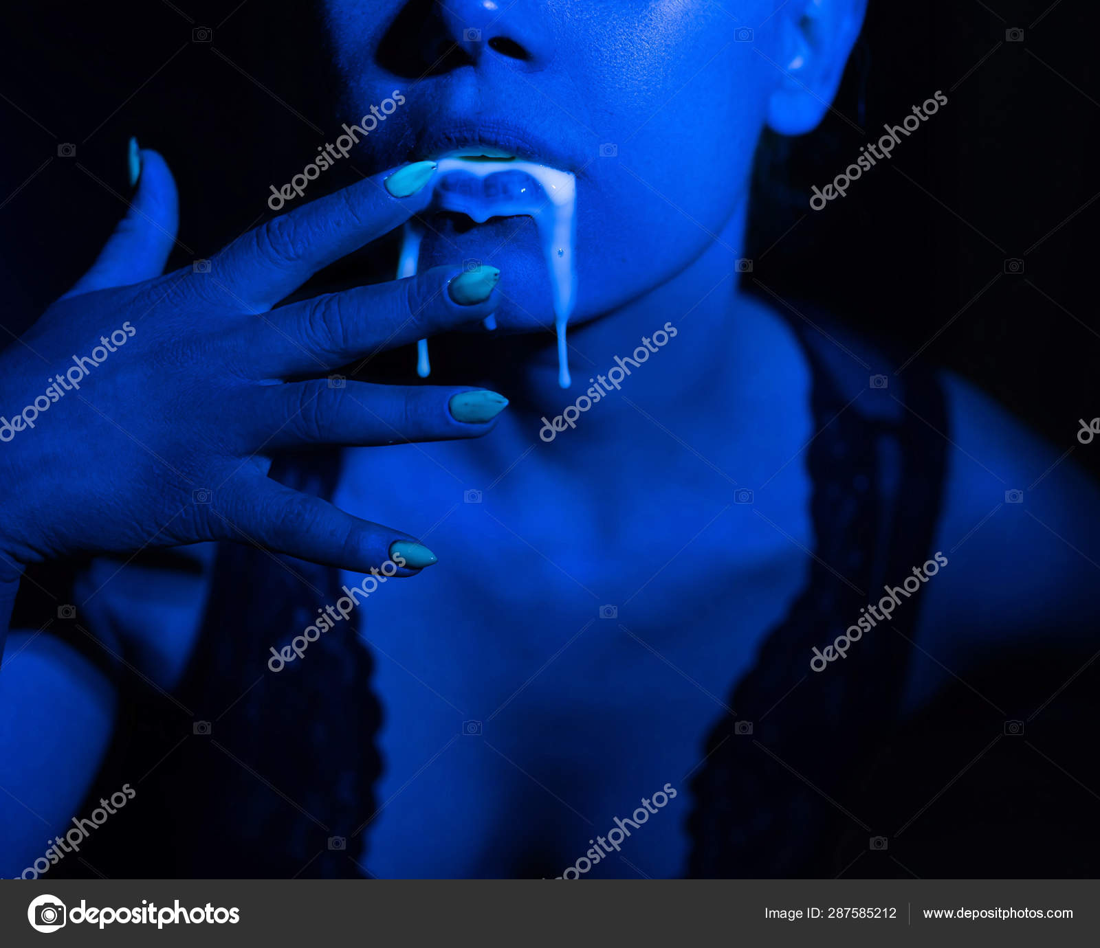 A thick white liquid flows down the lips of a young European girl ...