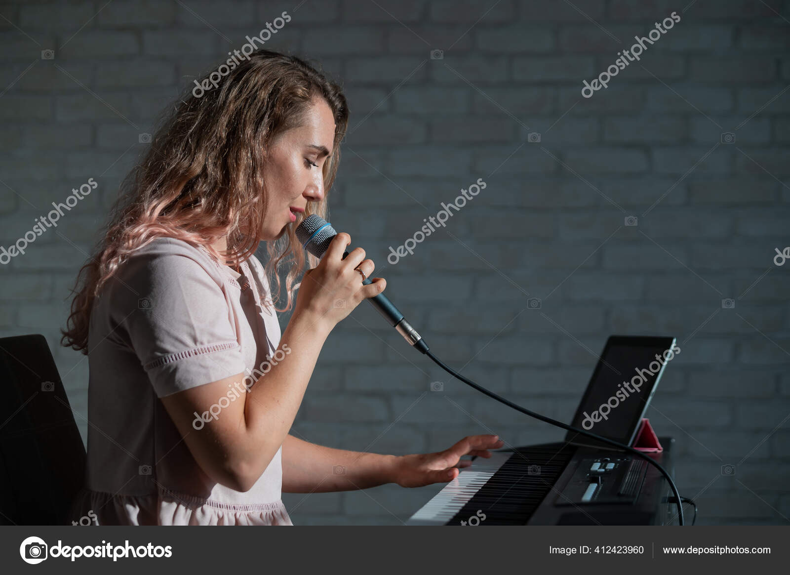 A woman records a vocal lesson using a laptop and accompanying on a ...
