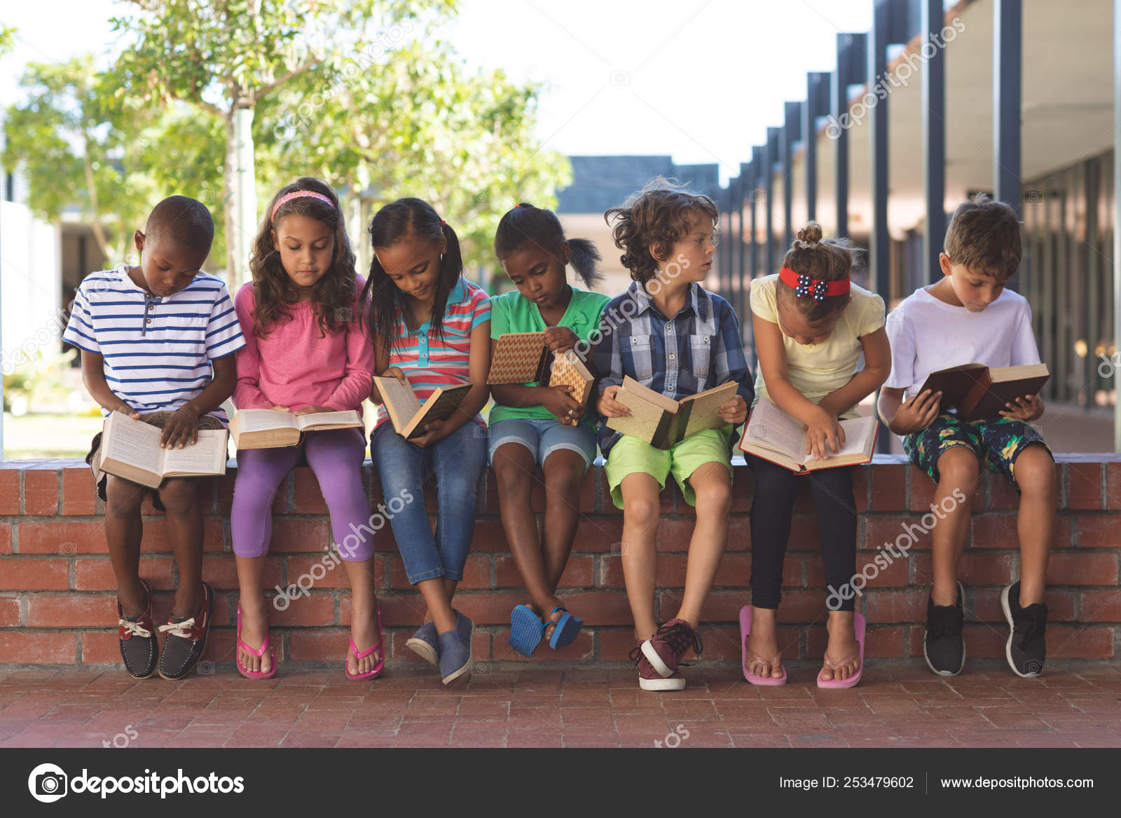 Front View Multi Ethnic Students Reading Books While Sitting Brick ...