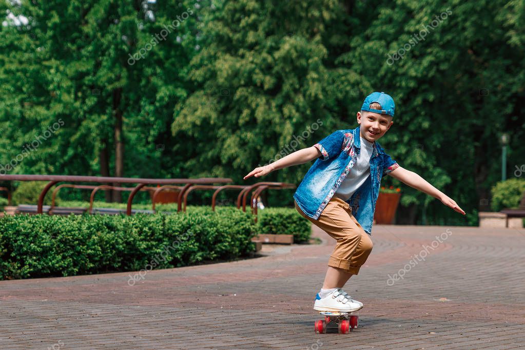 Un chico de ciudad y un monopatín. Un joven está montando en un parque ...