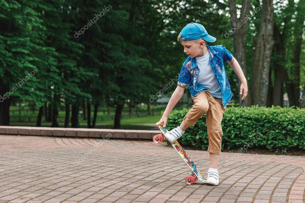 Un chico de ciudad y un monopatín. Un joven está montando en un parque ...