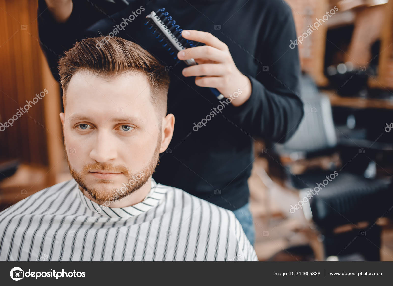 Close-up master Barber does hairstyle and styling with dryer hair to ...
