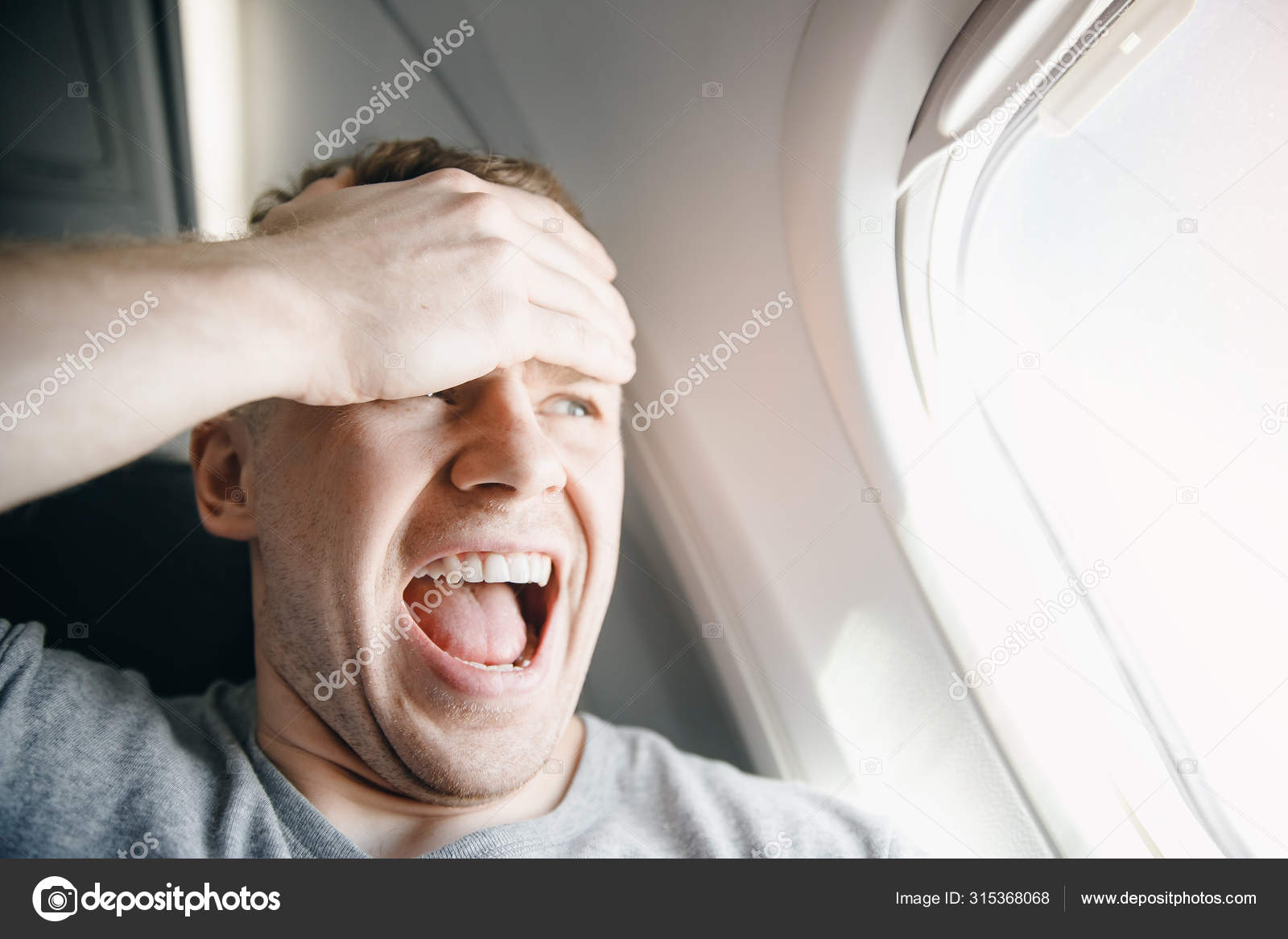 Passenger man in plane clutches his head, afraid of heights and flight ...