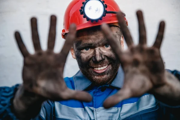 Miner angry man screams and frowns, holds sheet of paper for text ...
