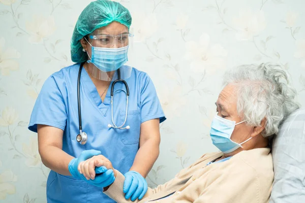 Asian doctor wearing face shield and PPE suit new normal to check ...