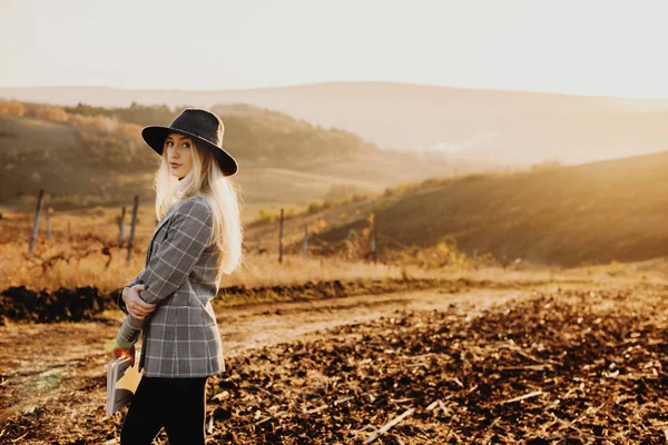 Beautiful young blonde writer looking into camera while holding her ...