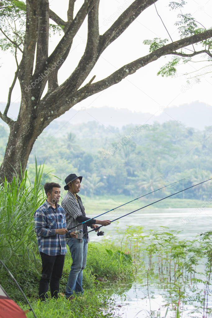 hombre se sienta en la orilla del río pescados de pesca 2024
