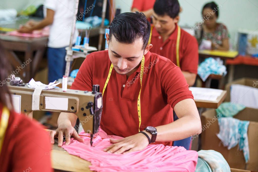 retrato del hombre cosiendo en una máquina de coser en una fábrica de ...