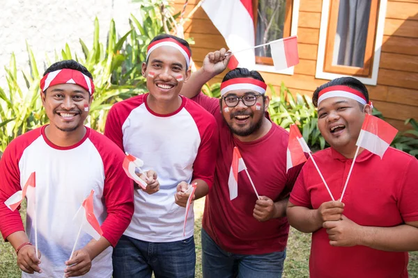 Four friends together holding indonesian flag celebrating independence ...